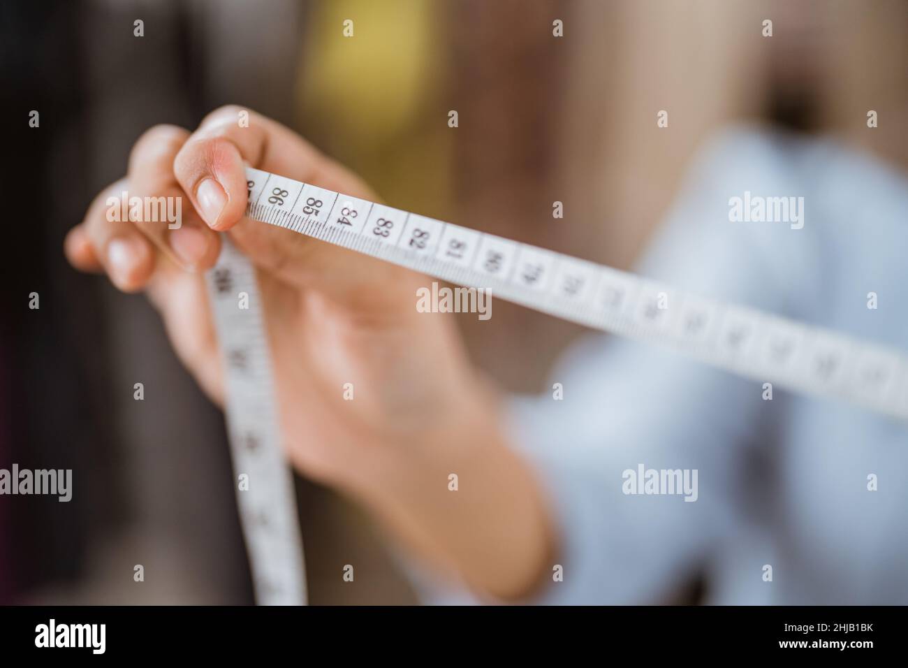 hand holding tape measure for making a dress Stock Photo - Alamy