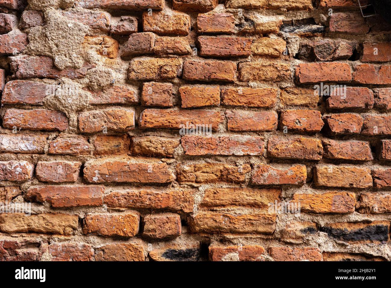 Brown rough brick wall of old building exterior with cracking parts and ...