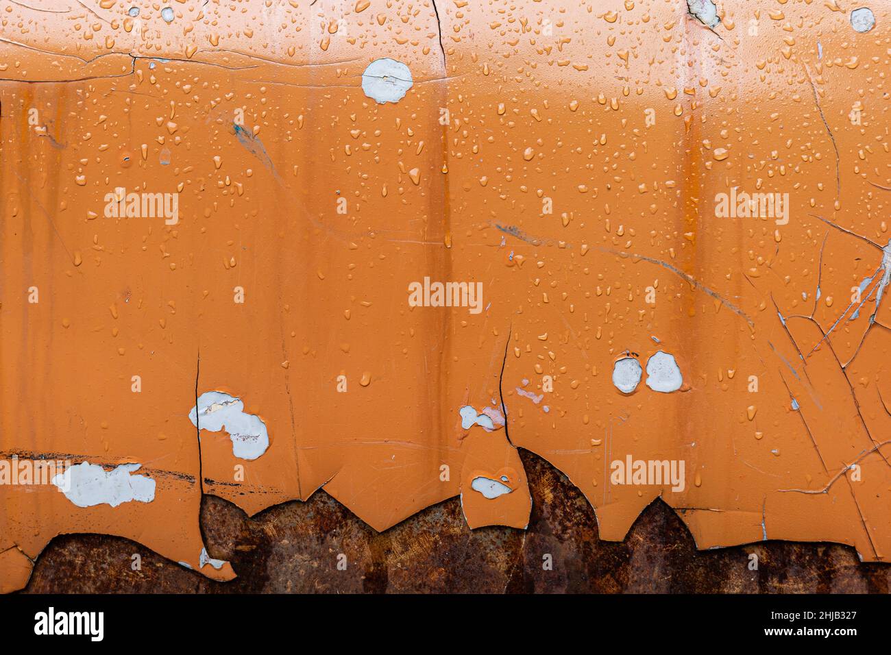 Close up on wet background of orange grunge and rusty metal surface ...