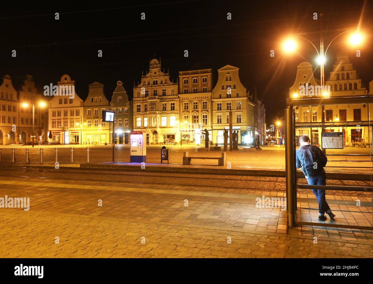 Rostock, Germany. 28th Jan, 2022. A man is standing at a streetcar stop ...