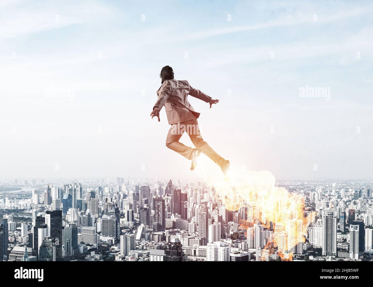 Businessman in suit and aviator hat flying in sky Stock Photo - Alamy