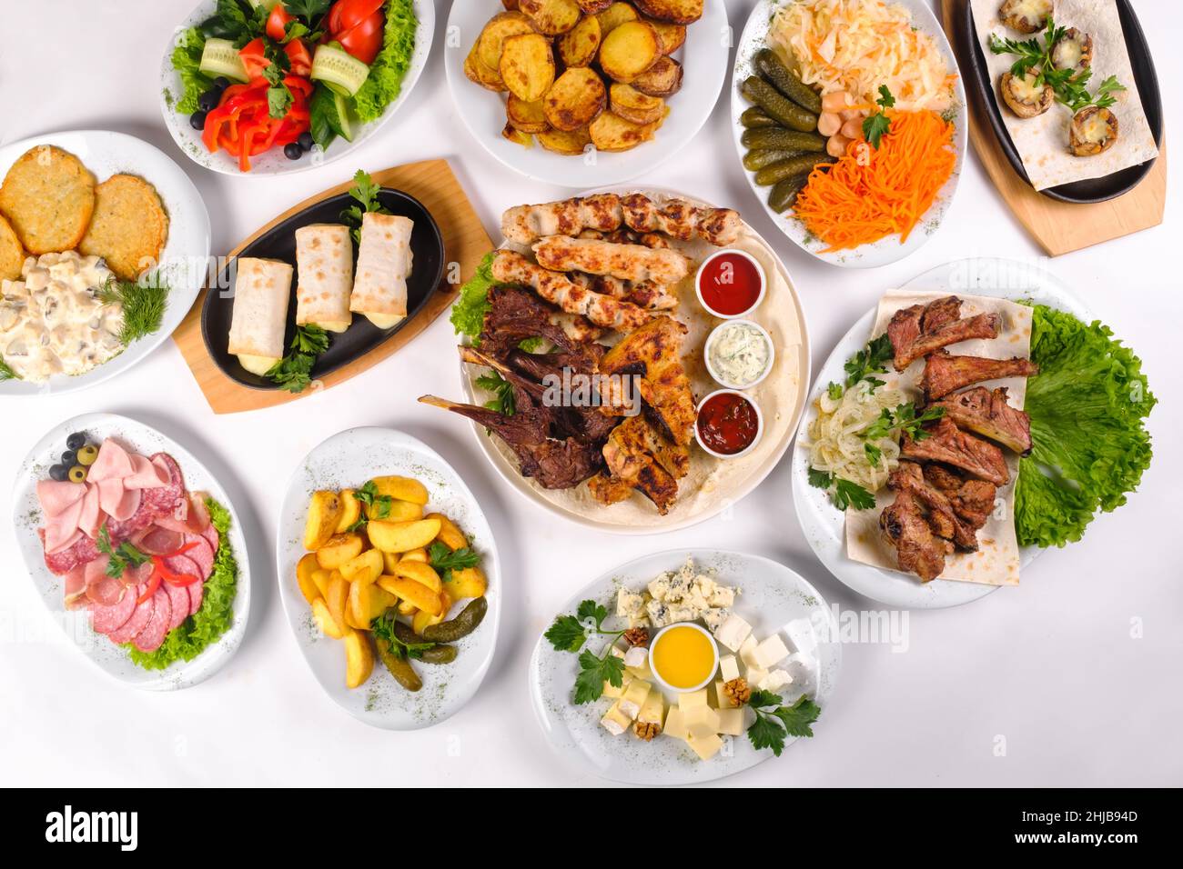 A covered table with many different dinner dishes. Lots of food on a ...