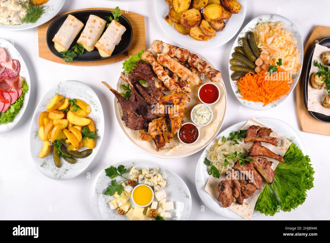 A covered table with many different dinner dishes. Lots of food on a ...