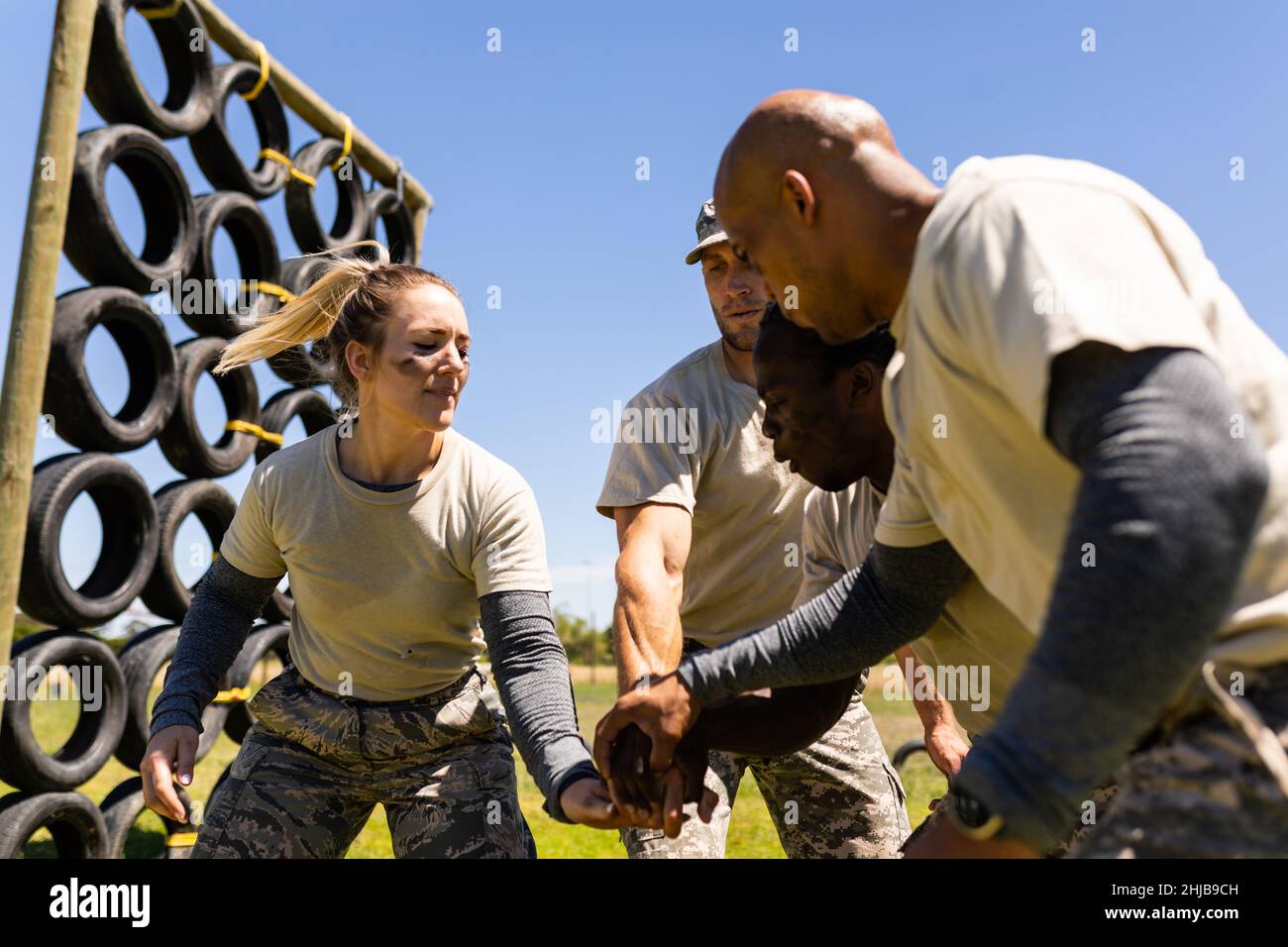 Group of diverse male and female soldiers stacking their hands together ...