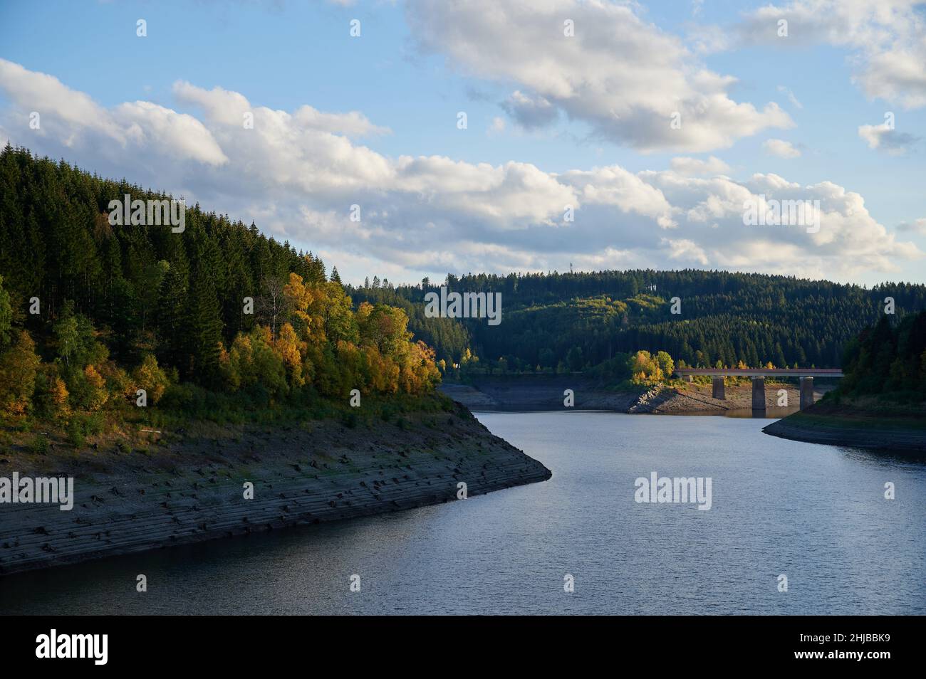 Landscape of a canal surrounded by Harz Mountains covered in forests in ...
