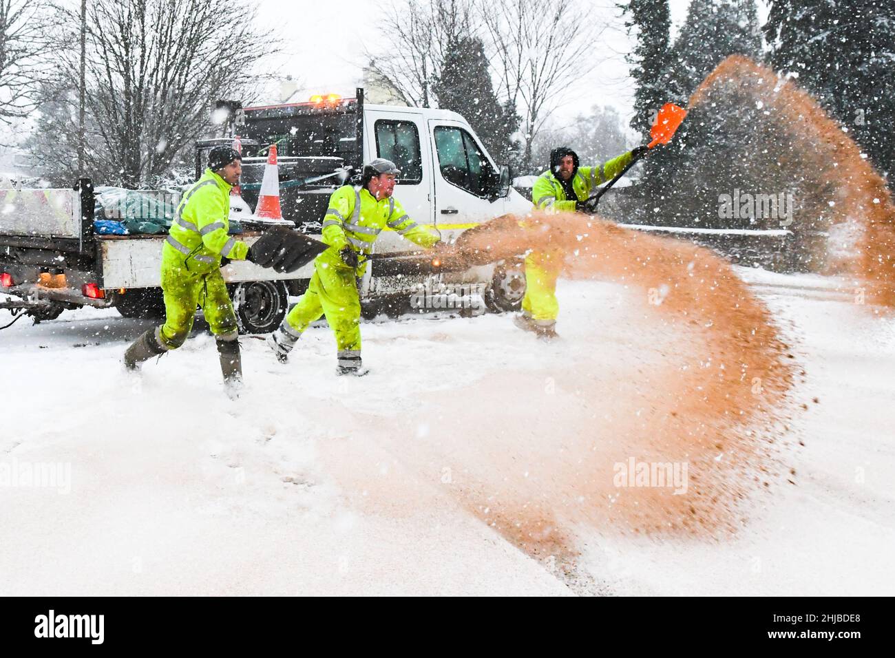 spreading grit salt on snow in car park during Beast from the East in ...