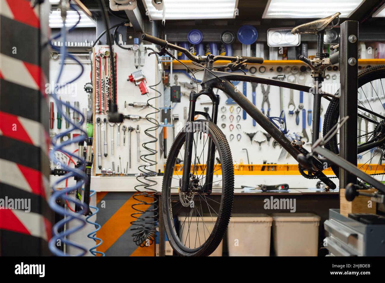 Modern bicycle and different instruments and working tools hanging on ...