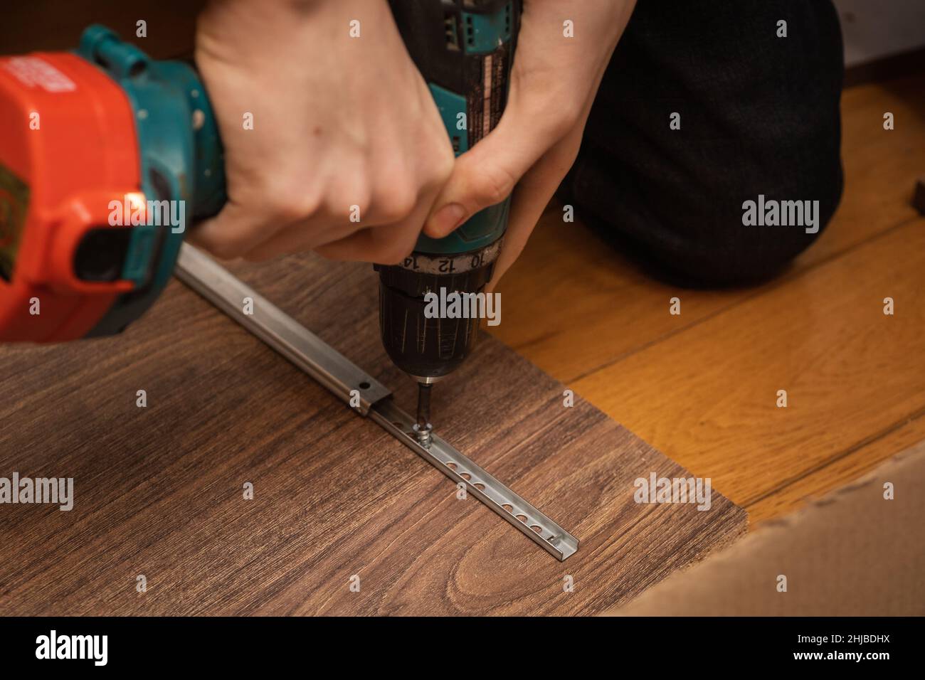 Screwing in screw with screwdriver to stick iron part detail to ...