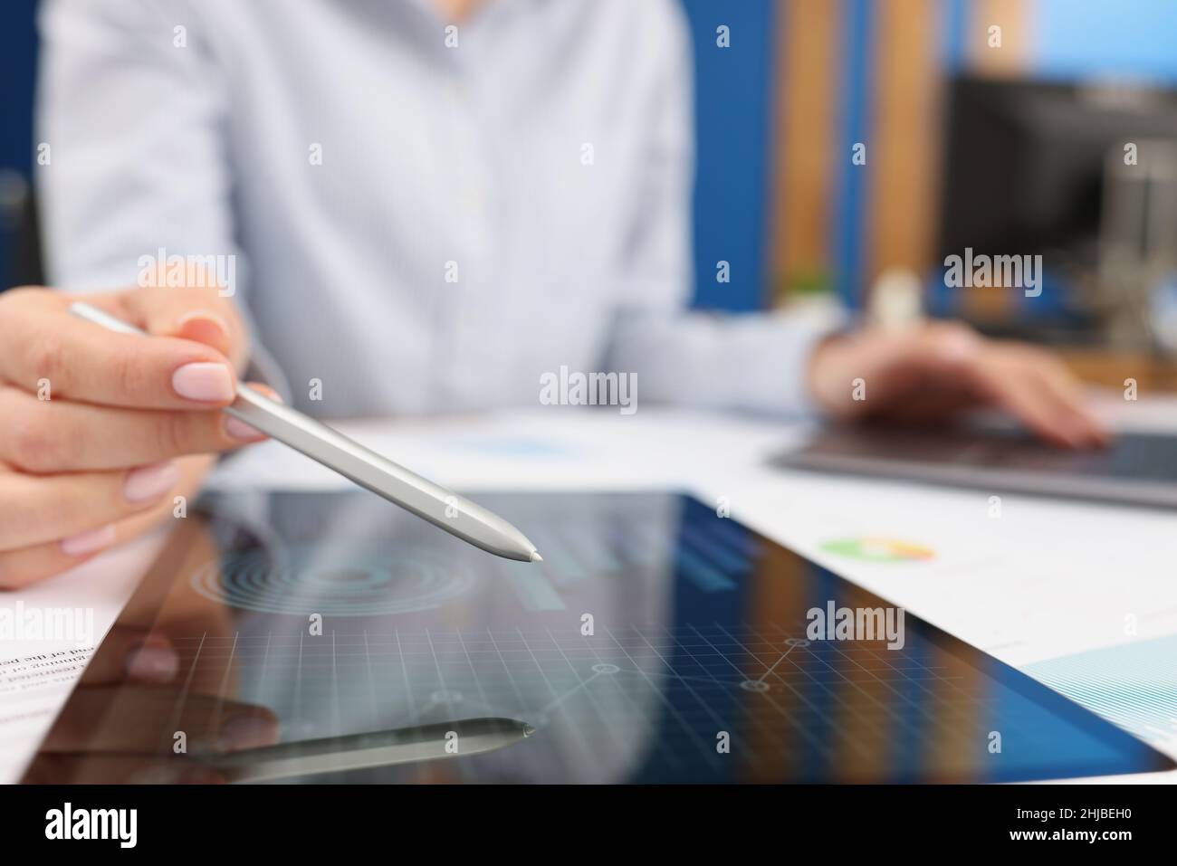 Female working on tablet with diagrams and charts on device screen ...
