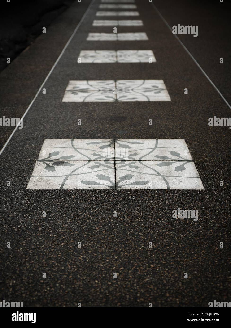 Ground level view of ornate paving stones receding into the background ...