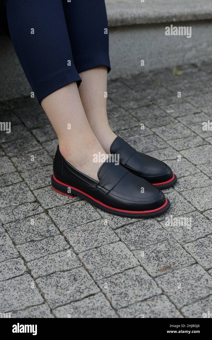 Female fashion concept. Womans legs in a black shoes with red line ...