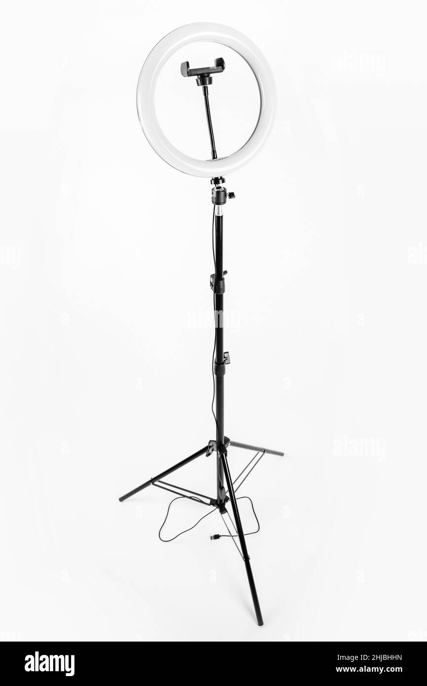 LED ring lamp on a high tripod. White background Stock Photo - Alamy
