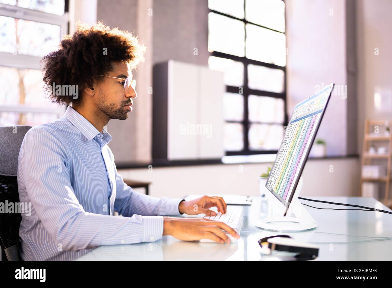 Data Analyst African Man Using Spreadsheet On Computer Stock Photo - Alamy