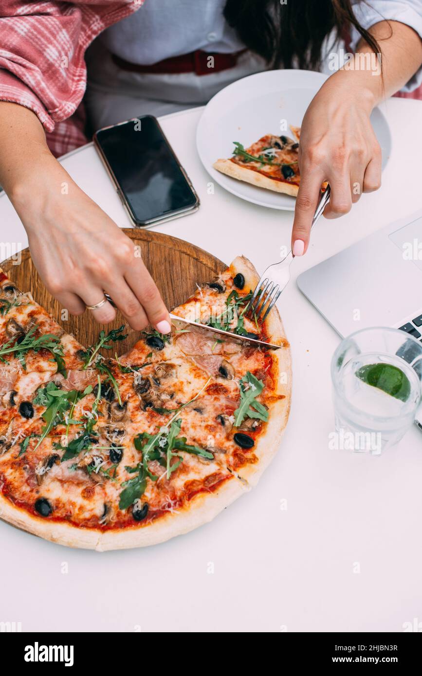 Top view of business woman working on a table at a pizza restaurant ...