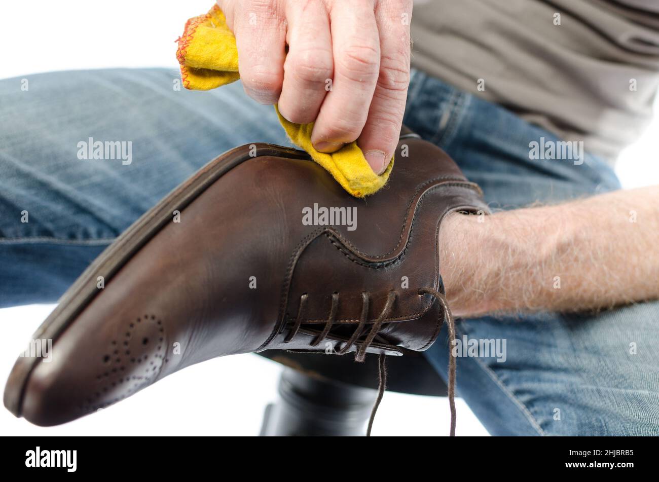 Shoe shiner shining a brown shoe with a yellow rag Stock Photo - Alamy