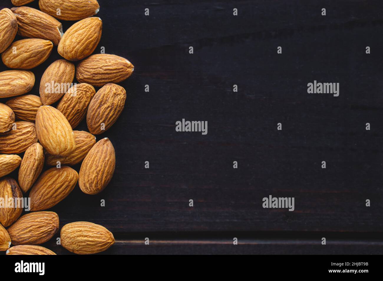Close up almonds on dark wooden table. Organic health protein ...