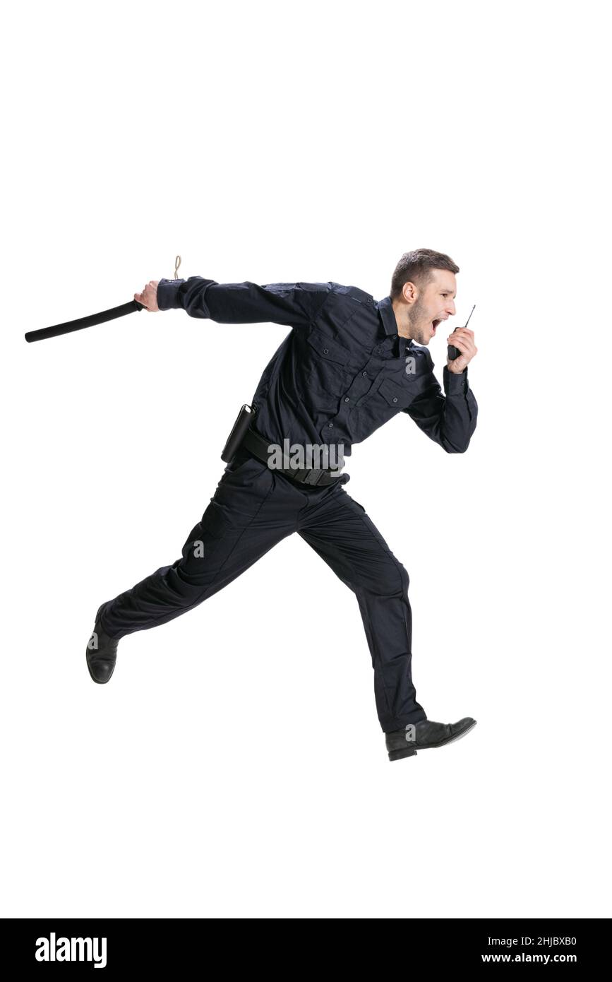 Dynamic portrait of young man, policeman officer wearing black uniform ...