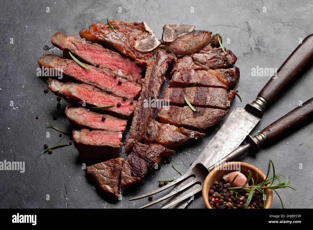 Grilled porterhouse beef steak. Sliced T-bone with herbs and spices ...