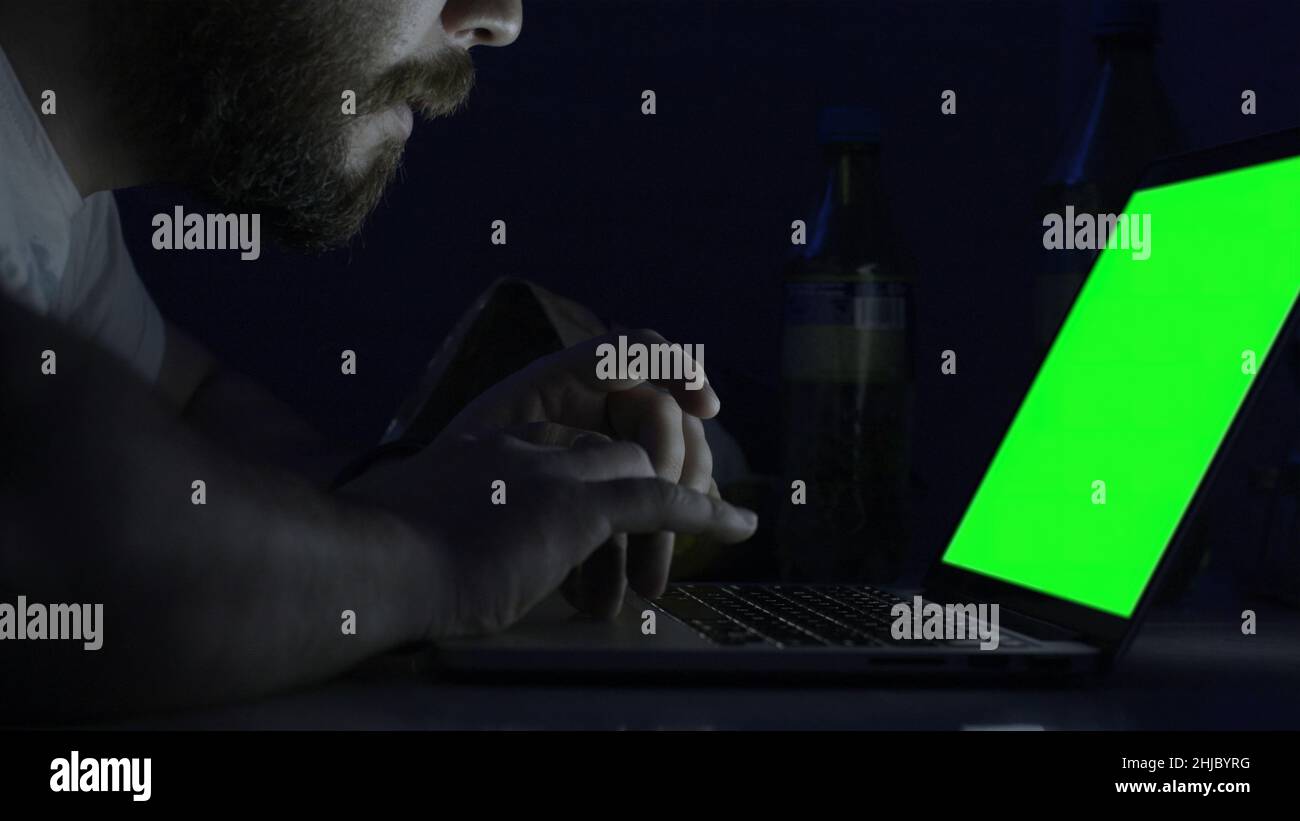 The young handsome man learn in his computer at night. Man using the ...