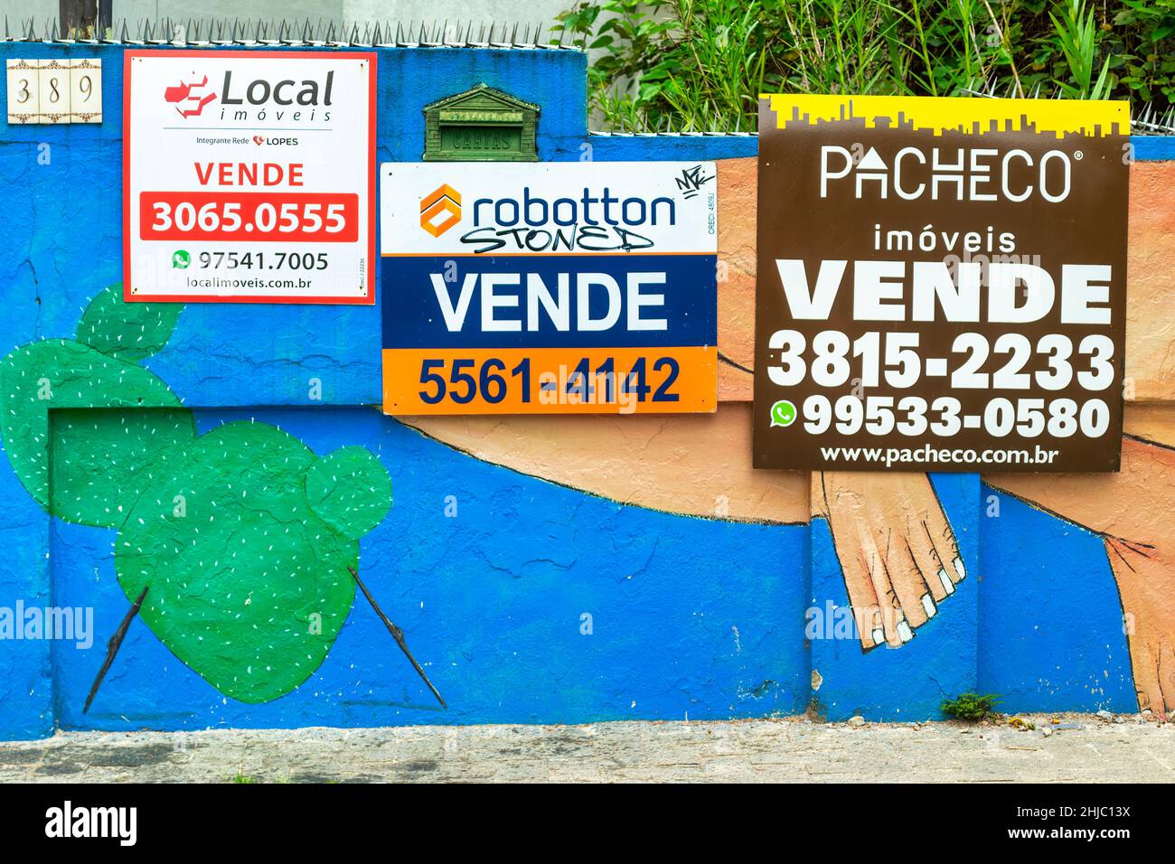 Advertisement signs in a colourful fence in the city Stock Photo - Alamy