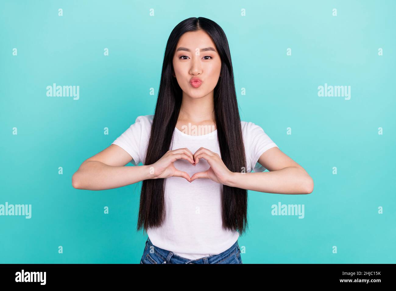 Photo of young asian girl pouted lips send air kiss show fingers heart ...