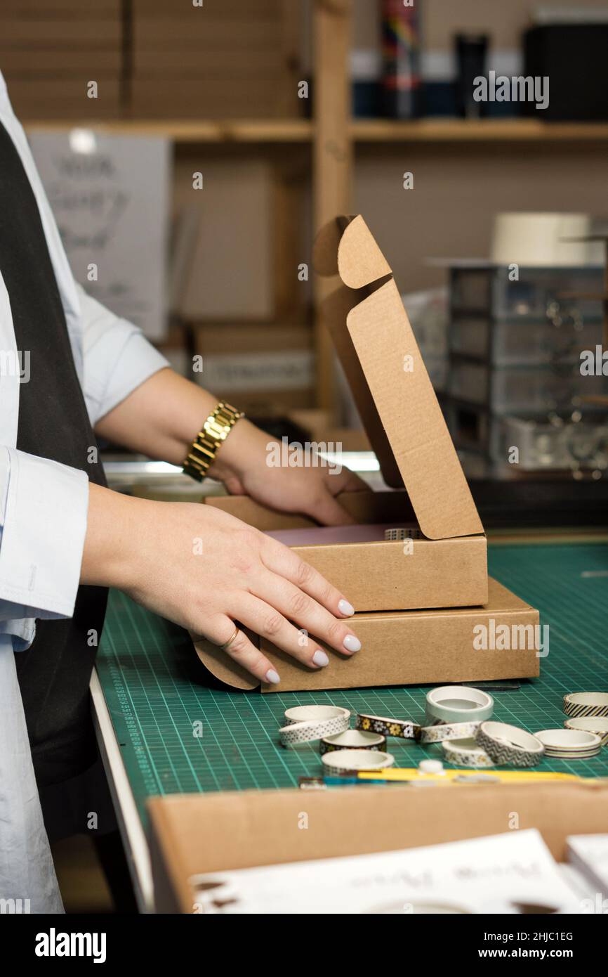 Packing goods in cardboard boxes in the warehouse before delivery ...
