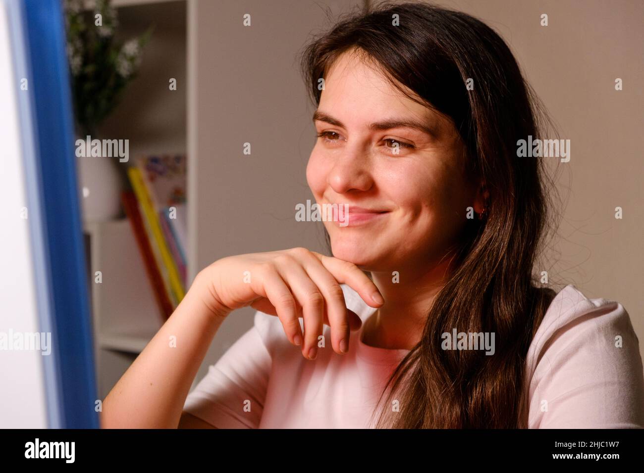 The woman looks at the computer screen and smiles Stock Photo - Alamy
