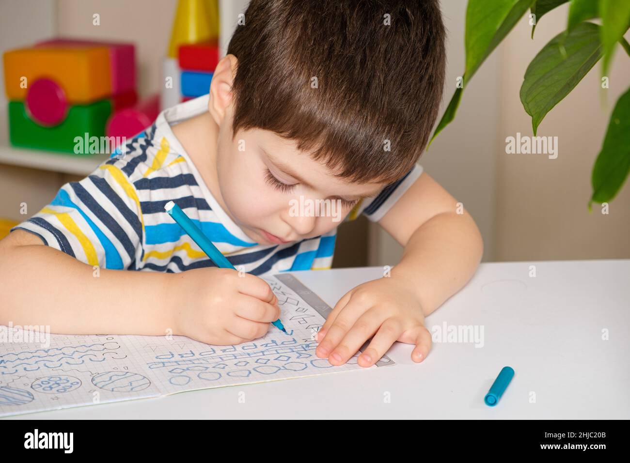 Preschool child learns to write, writes copybook Stock Photo - Alamy