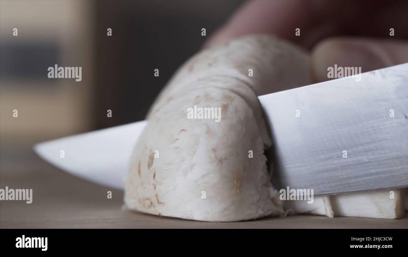 Pieces of champignons, close up of hands cutting the mushrooms into ...