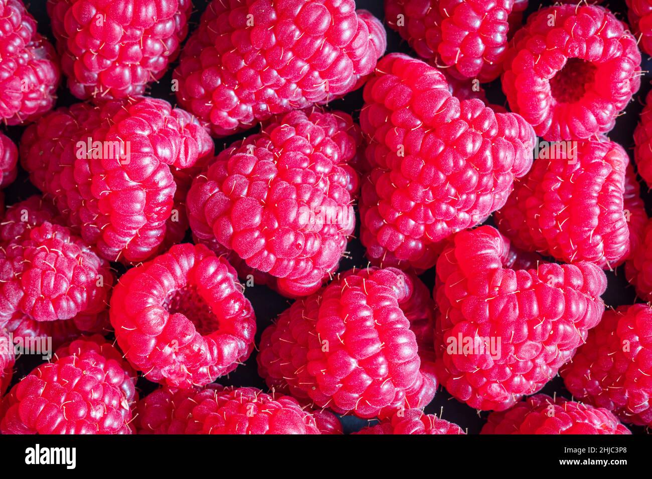 Fresh and ripe raspberries background closeup Stock Photo - Alamy