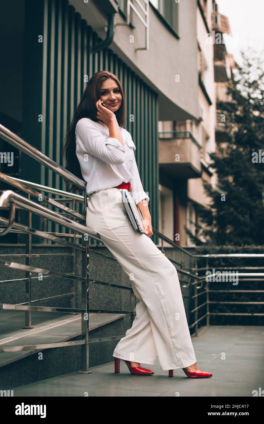 Beautiful young caucasian businesswoman in a white clothes with a ...