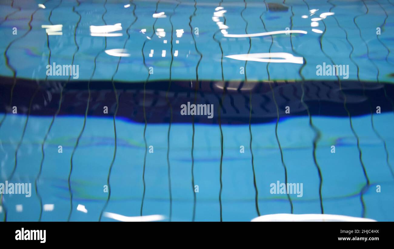 Blur of light reflecting in blue water of the pool. Clear water swaying ...