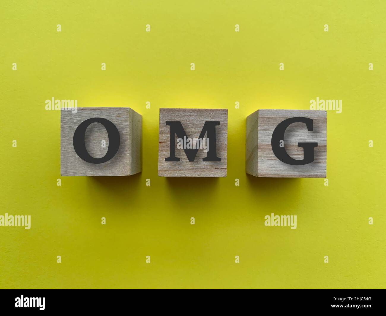 Alphabets of OMG on wooden blocks with yellow background Stock Photo ...