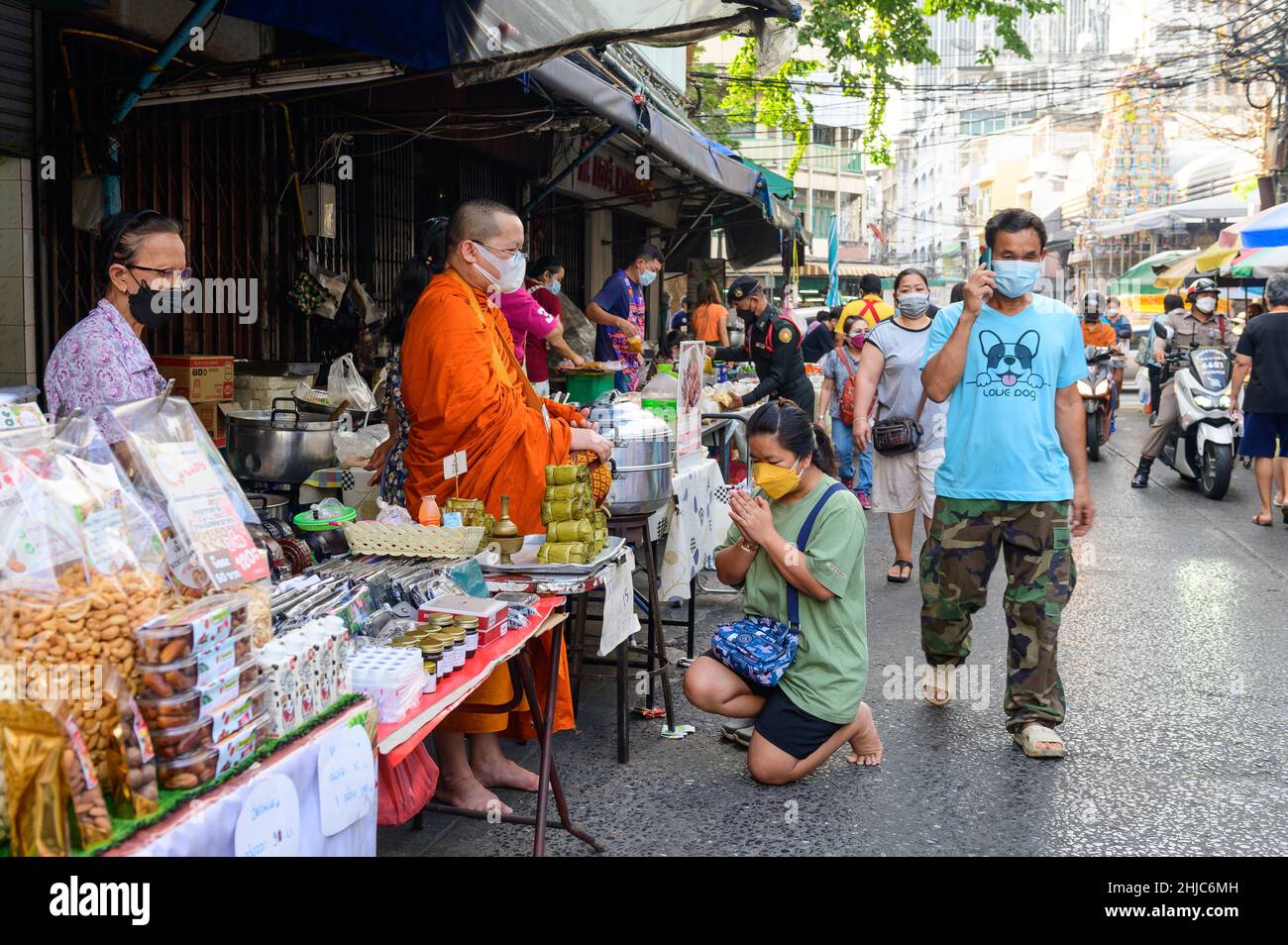 People praying respect to monk on Bangkok street Stock Photo - Alamy