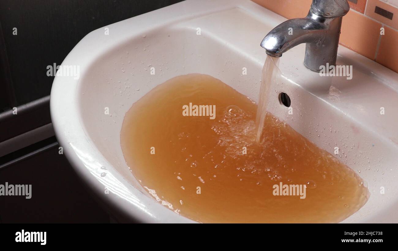 Rusty Water Pours From Tap. Water Pollution. Global Environment Stock ...