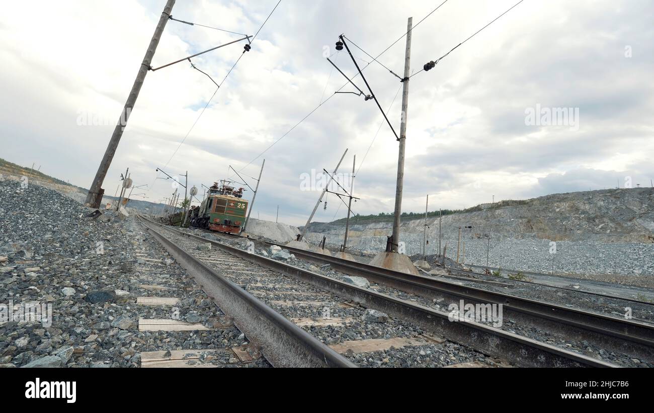 Moving of diesel locomotive and railway cars filled with ore. Quarry ...