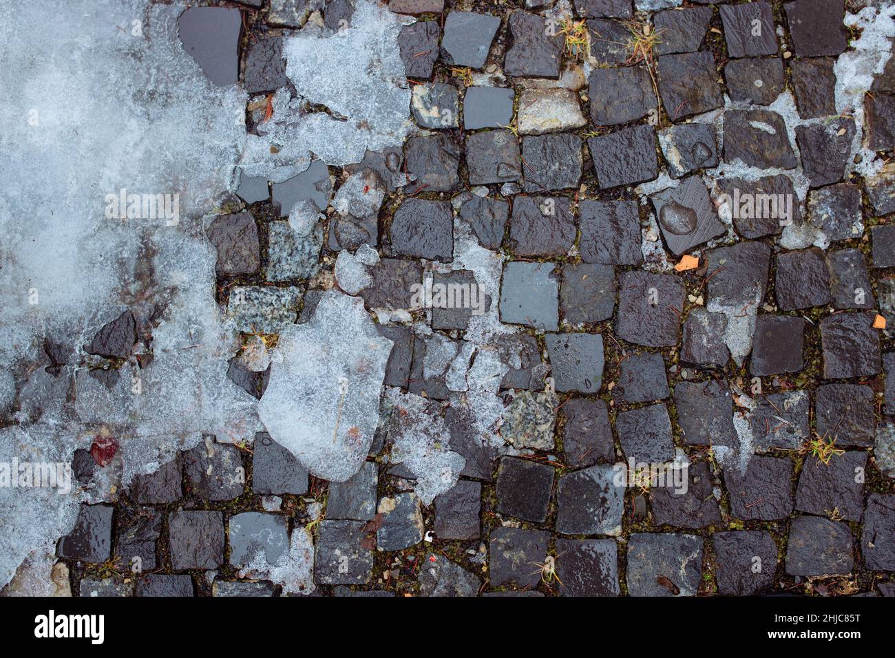 Ice residue on the paving stones. Sprinkled trail with reagents melted ...