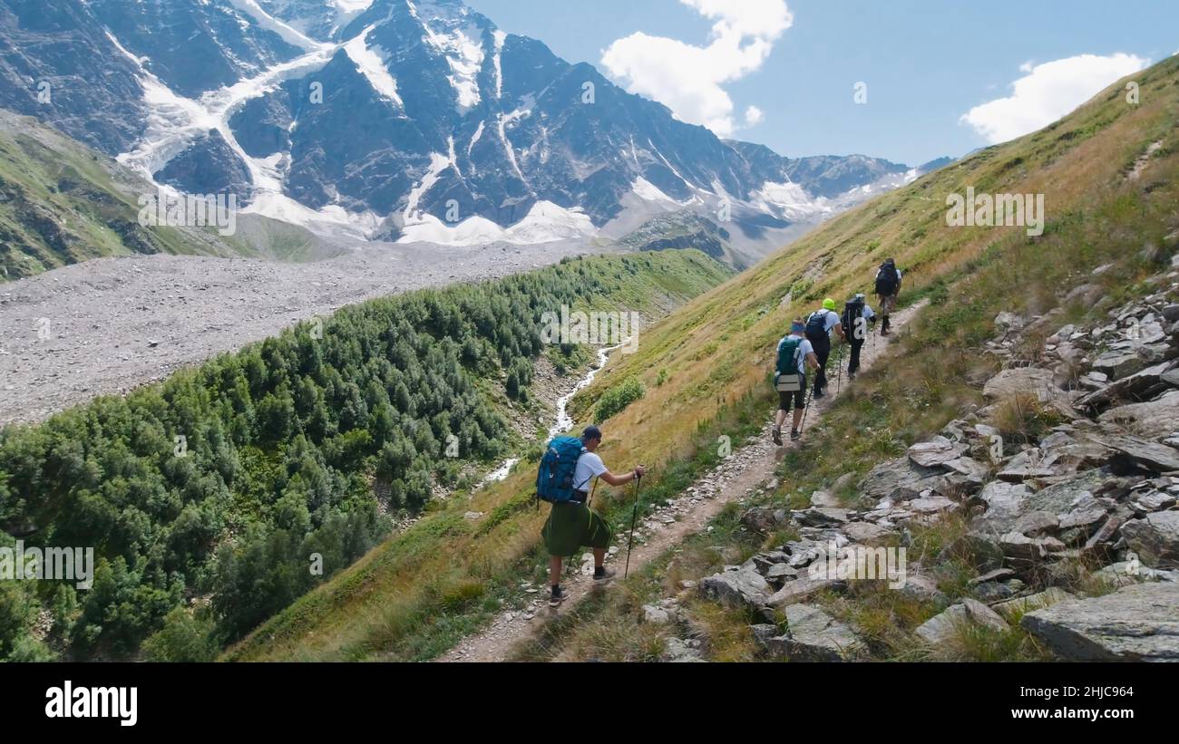 Active tourists go to mountains on sunny day. Clip. Tourists make ...