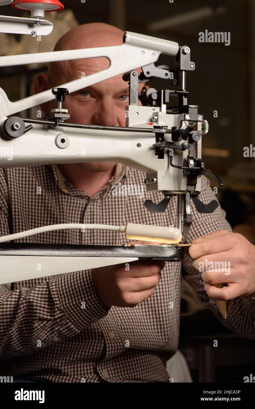 Industrial sewing machine in workshop of shoemaker. Bootmaker setting ...