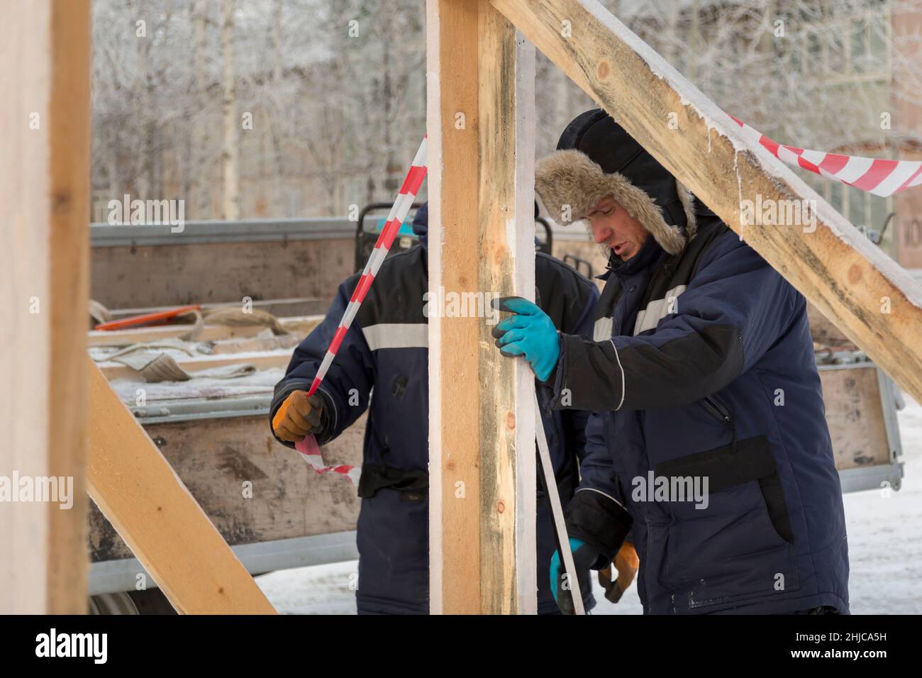Two workers assemble the slide frame from wooden beams Stock Photo - Alamy