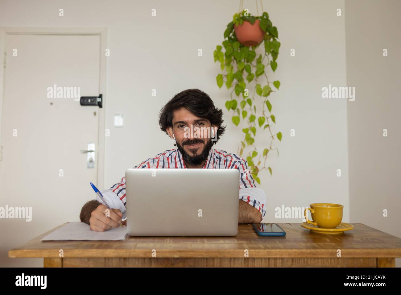 Young business man working at home with laptop and papers on desk. Gray ...