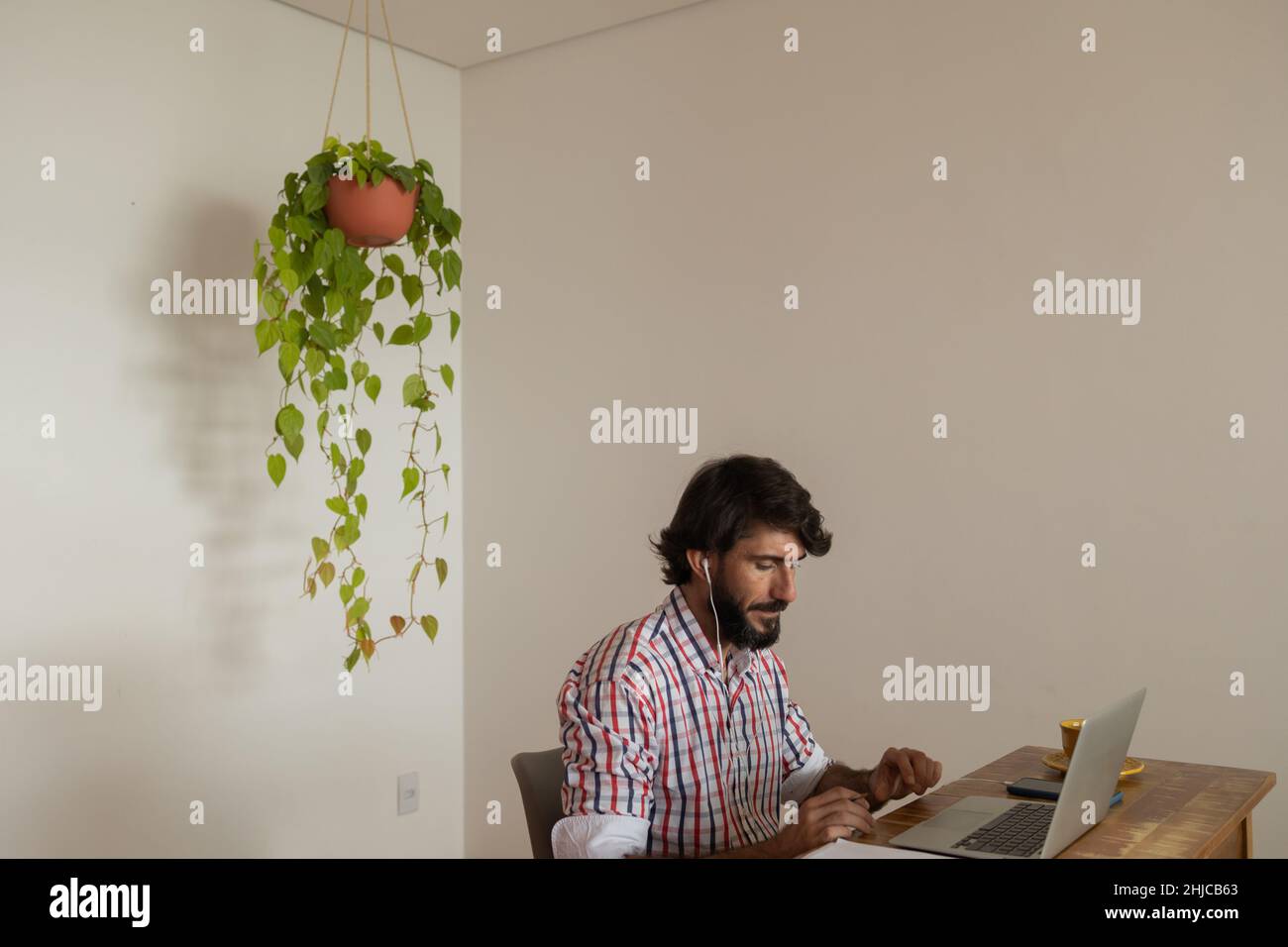 Young business man working at home with laptop and papers on desk. Gray ...