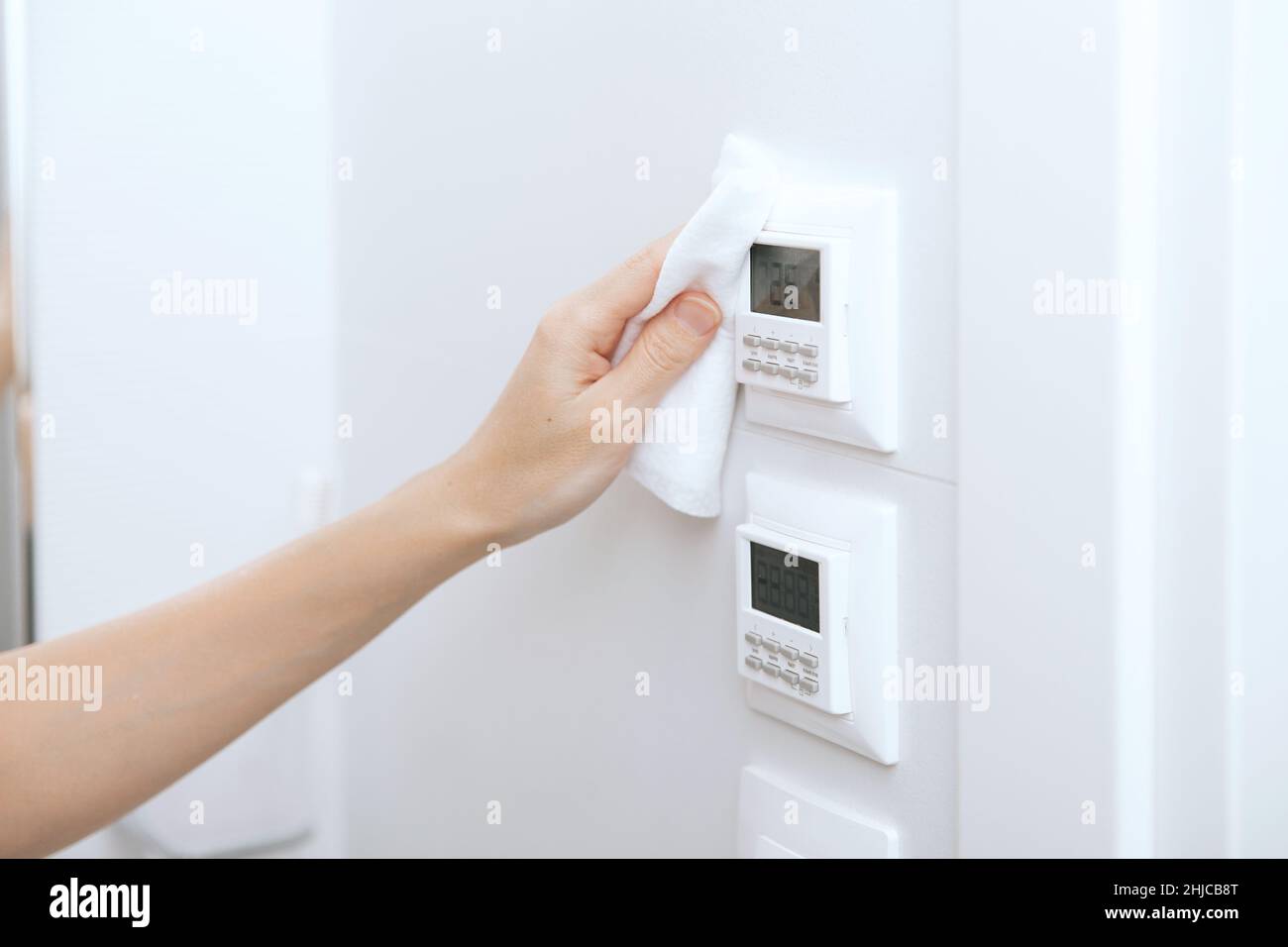 Cleaning switches and sockets with a microfiber cloth. Woman hand using ...