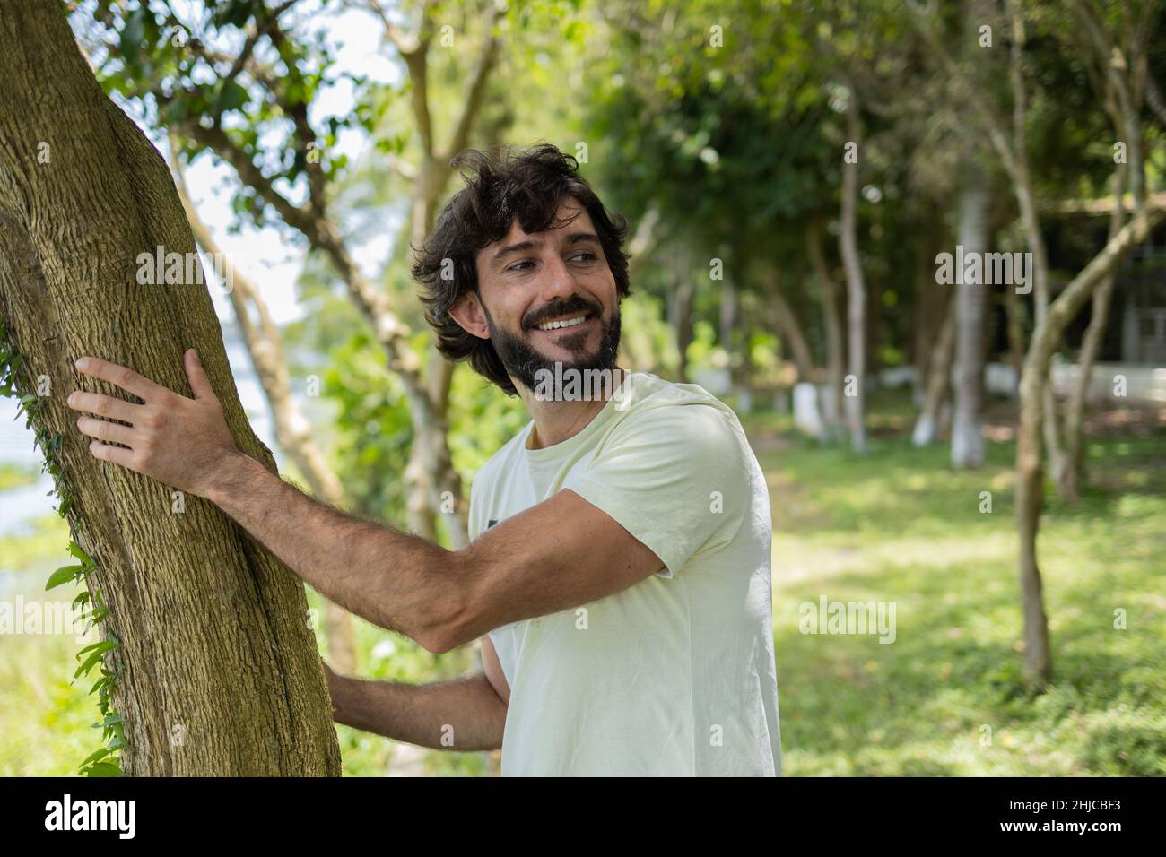 Portrait of smiling young man at a park on a beautiful sunny day. Man ...