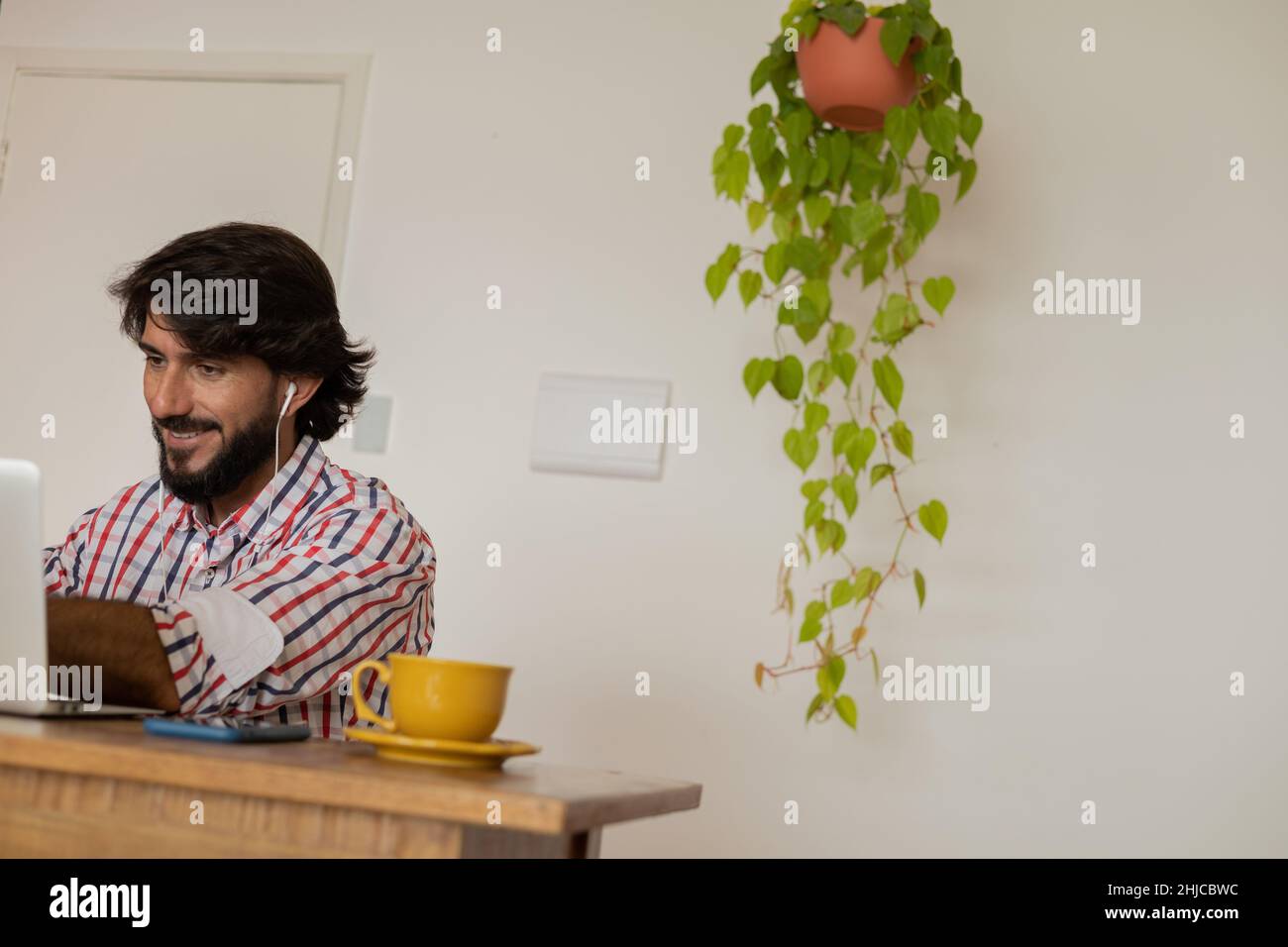 Young business man working at home with laptop and papers on desk while ...