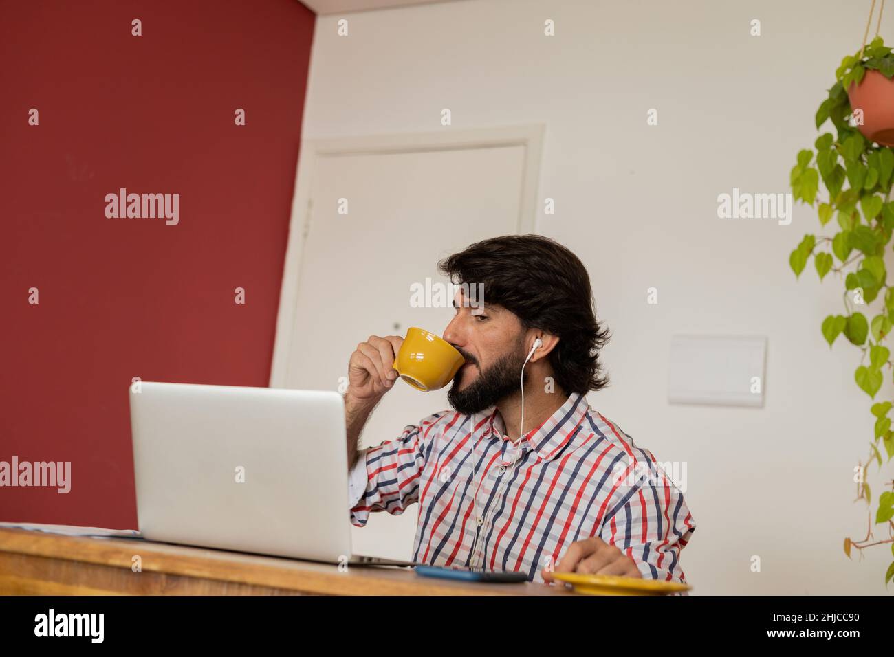 Young business man working at home with laptop and papers on desk while ...