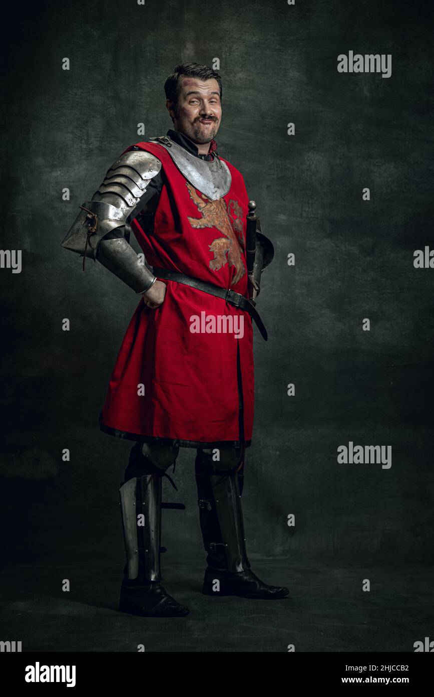 Portrait of smiling man in image of medieval warrior with dirty wounded ...