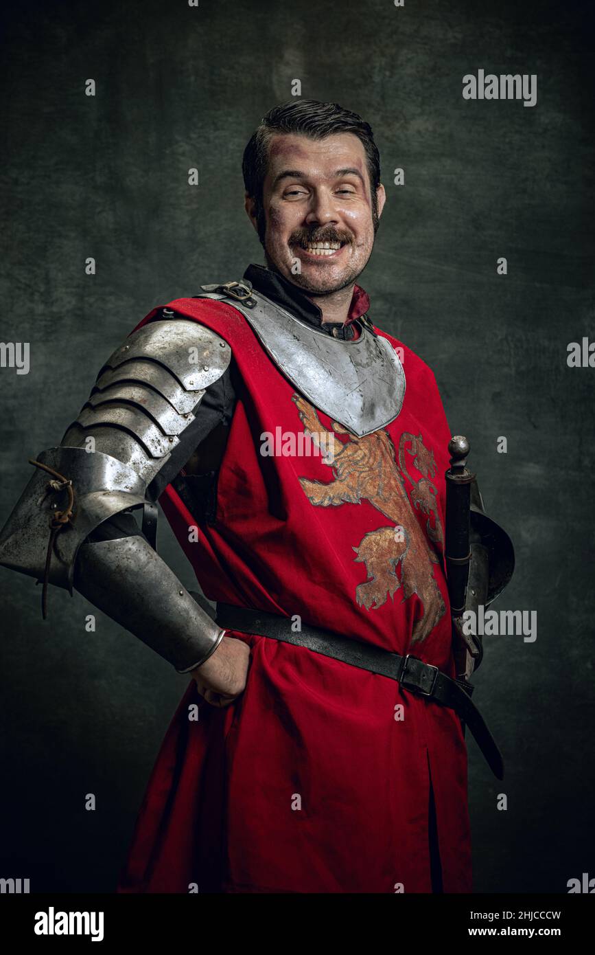 Portrait of smiling man in image of medieval warrior with dirty wounded ...