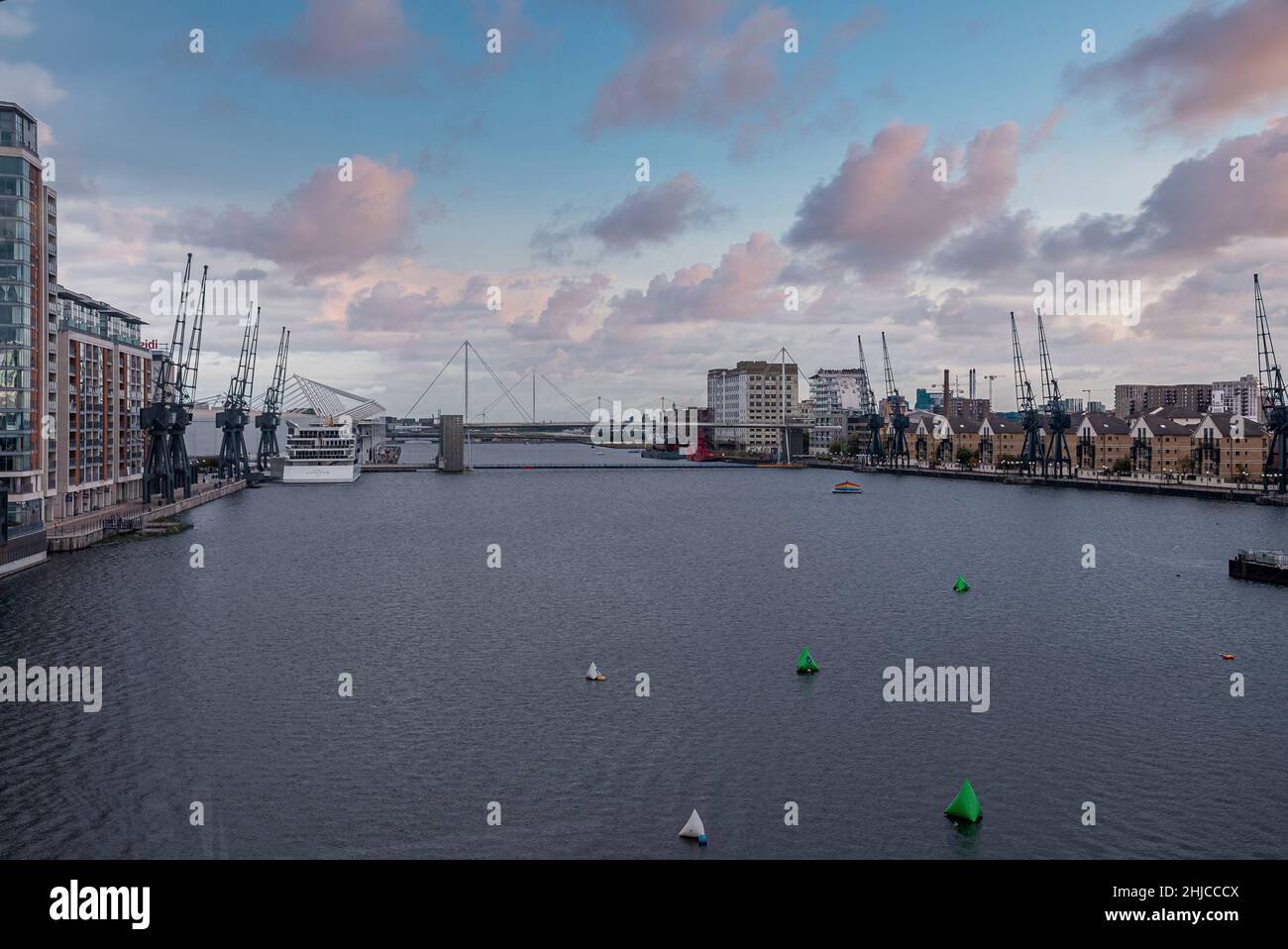 Port cranes with cityscape alongside river thames at royal victoria ...