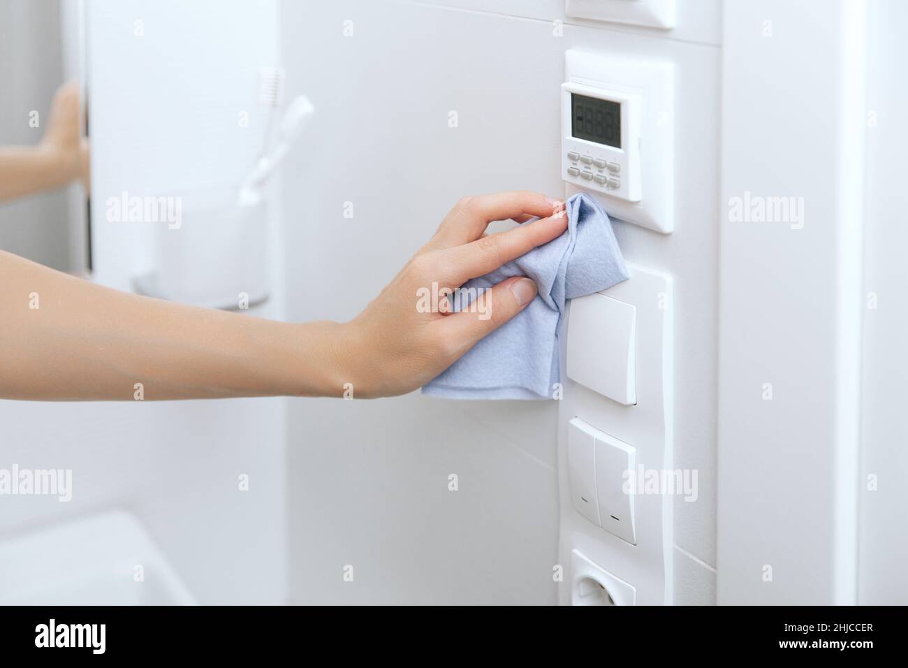 Cleaning switches and sockets with a microfiber cloth. Woman hand using ...